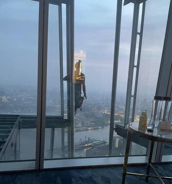 Couple wave at barefoot man climbing past their window at the Shard 40 ...