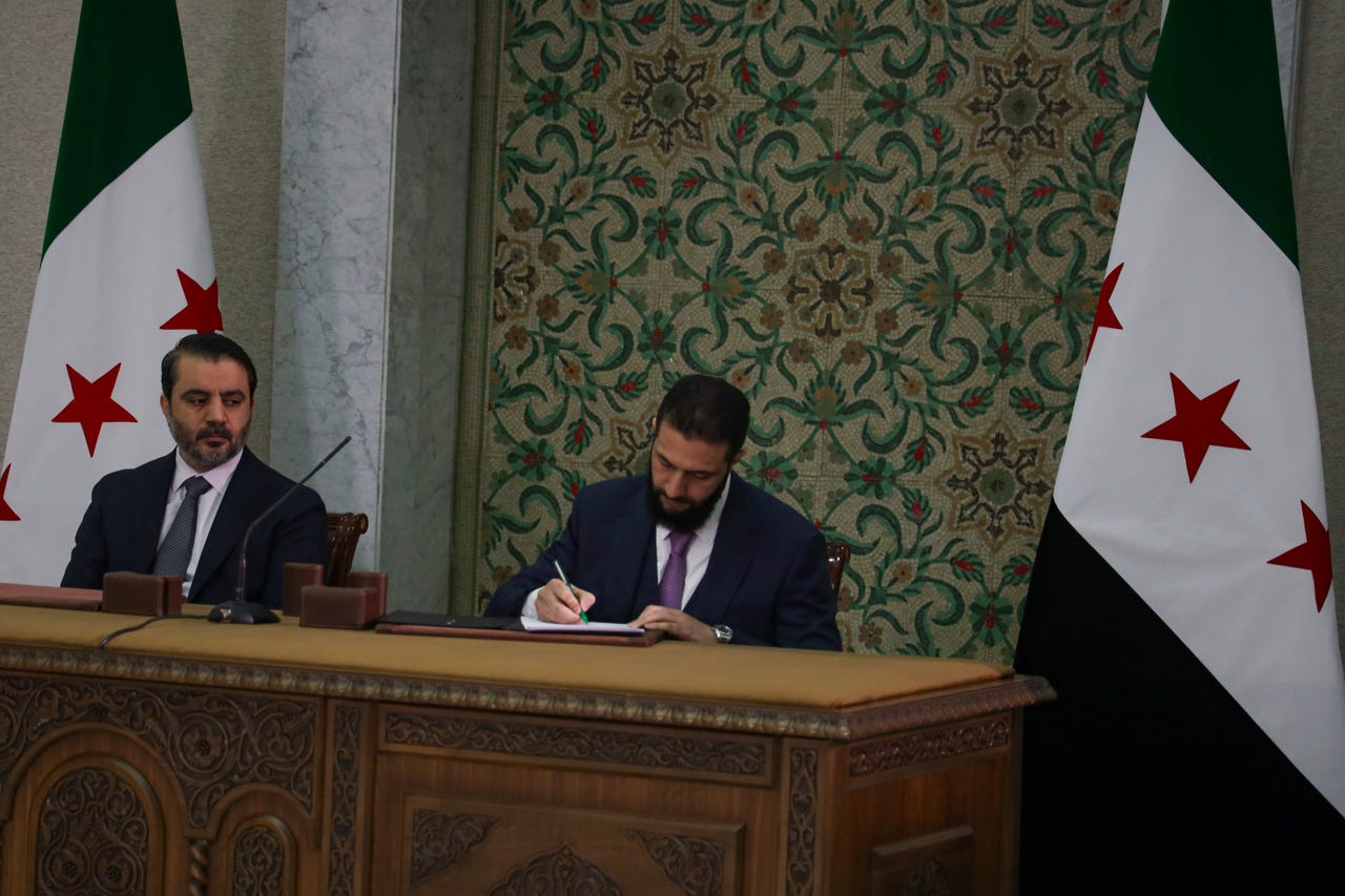 Syrian leader signs temporary constitution putting country under ...