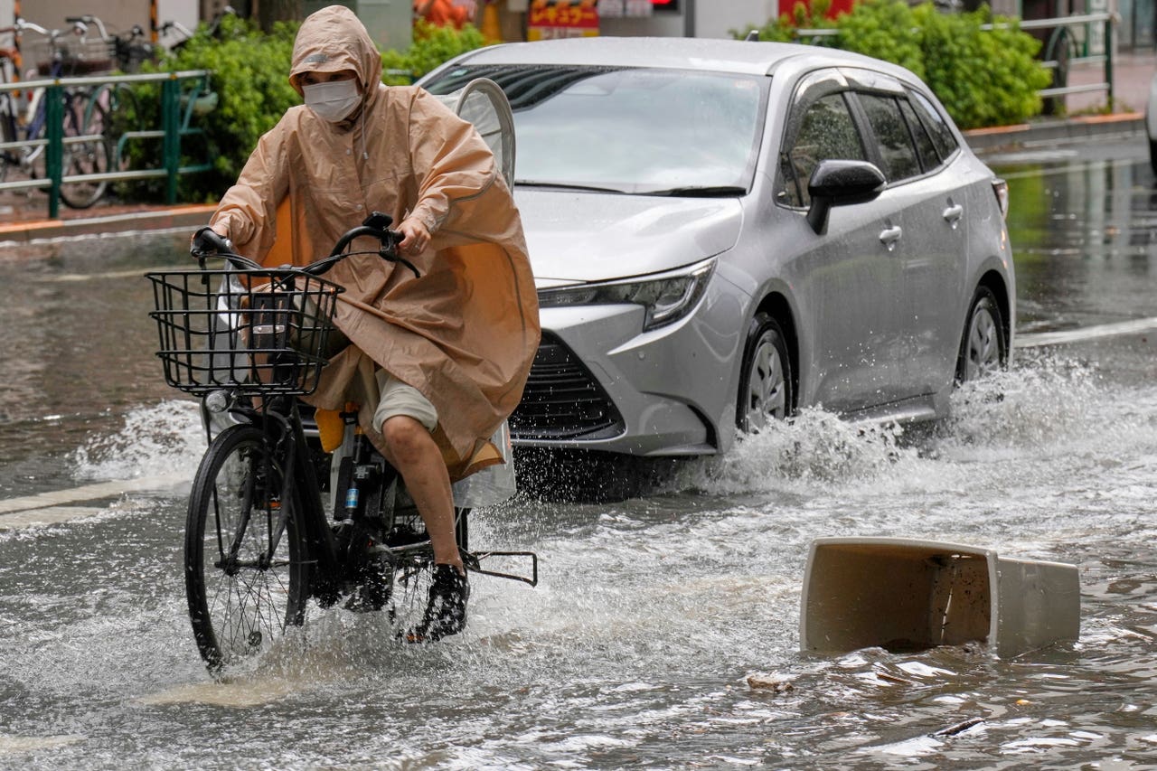 Heavy rain floods streets and halts air and rail travel in Tokyo ...